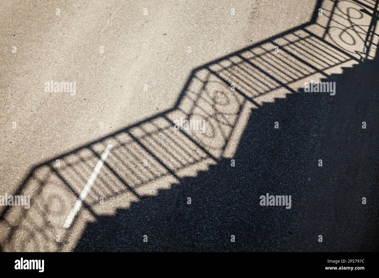 Railing shadow pattern on an empty road asphalt. Simple industrial ...