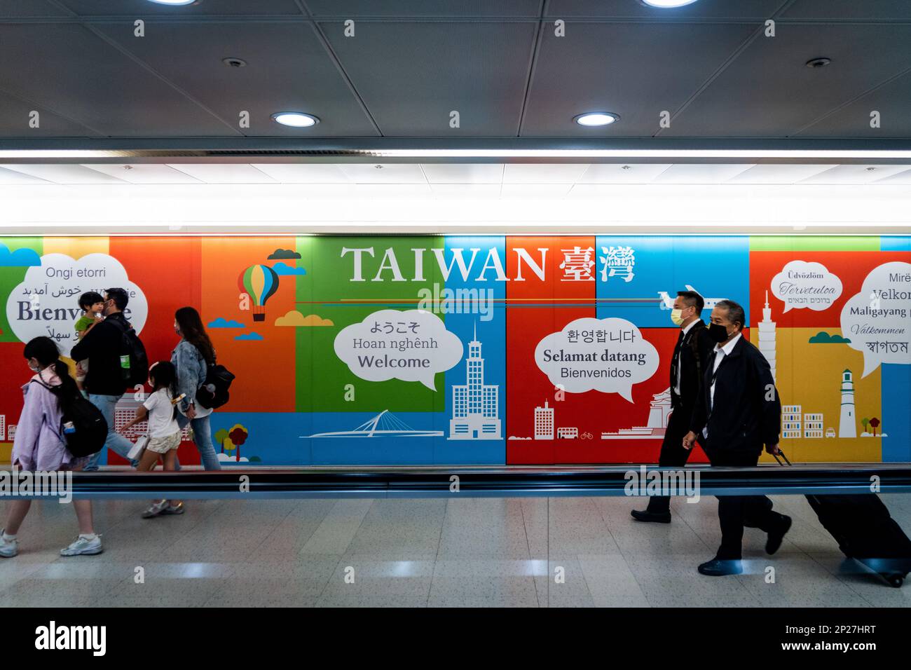 People arriving at Taiwan Taoyuan International Airport (TPE) walk pas ...