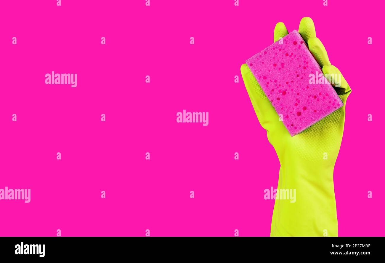 Hand in yellow glove holding pink washing sponge. Cleaning service ads ...