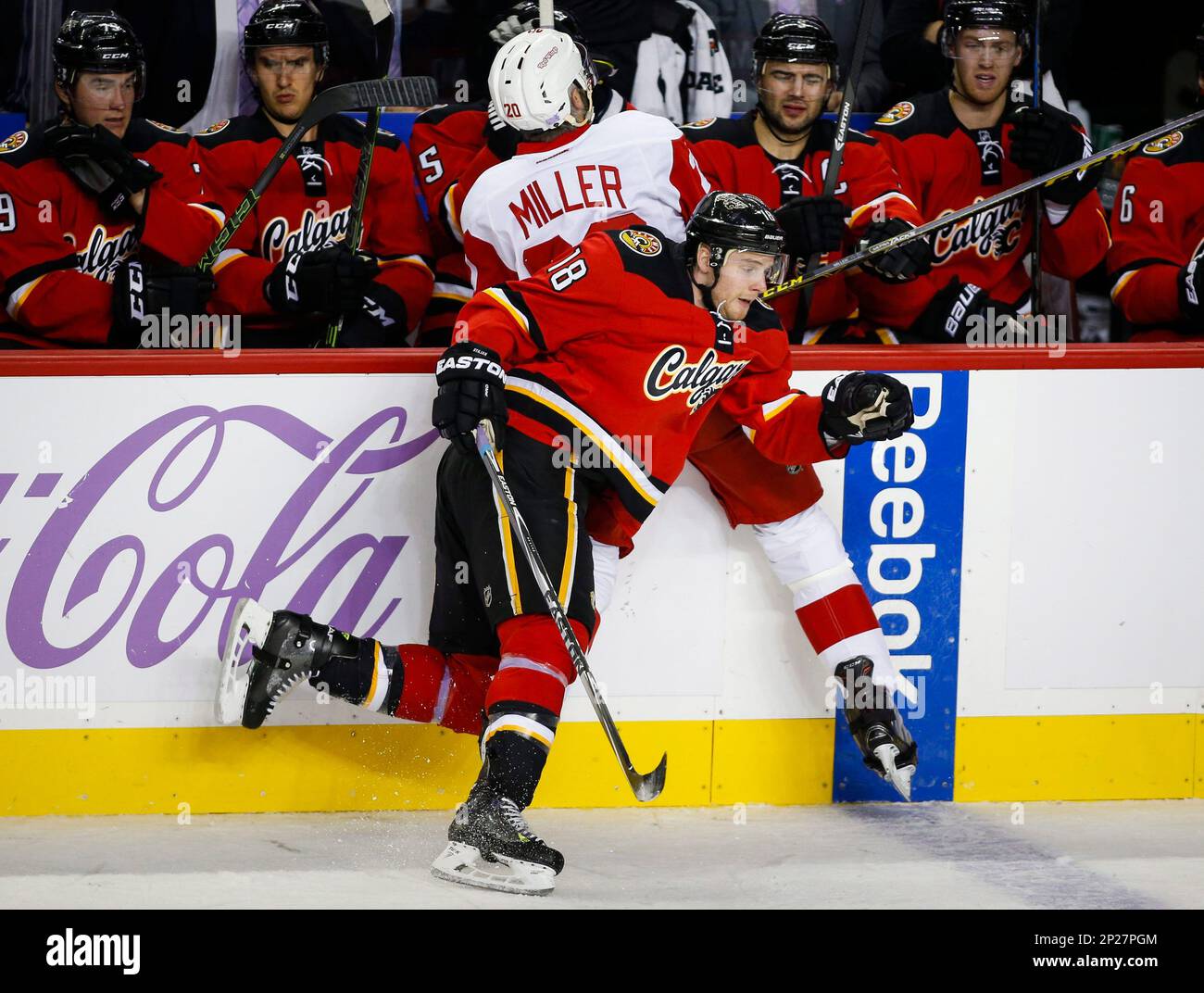 Detroit Red Wings' Drew Miller, left, is checked by Calgary Flames ...