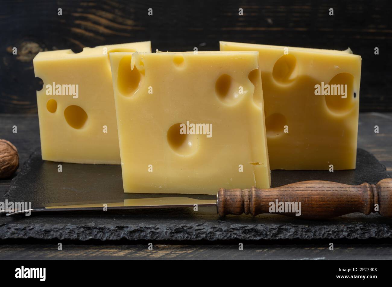 Block of Swiss medium-hard yellow cheese emmental or emmentaler with ...