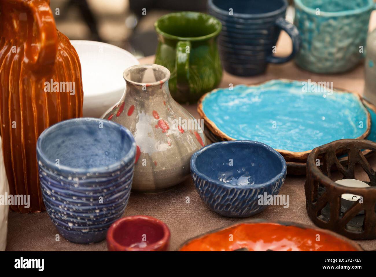 Lots of handmade tableware - ceramic cups, plates at pottery shop ...