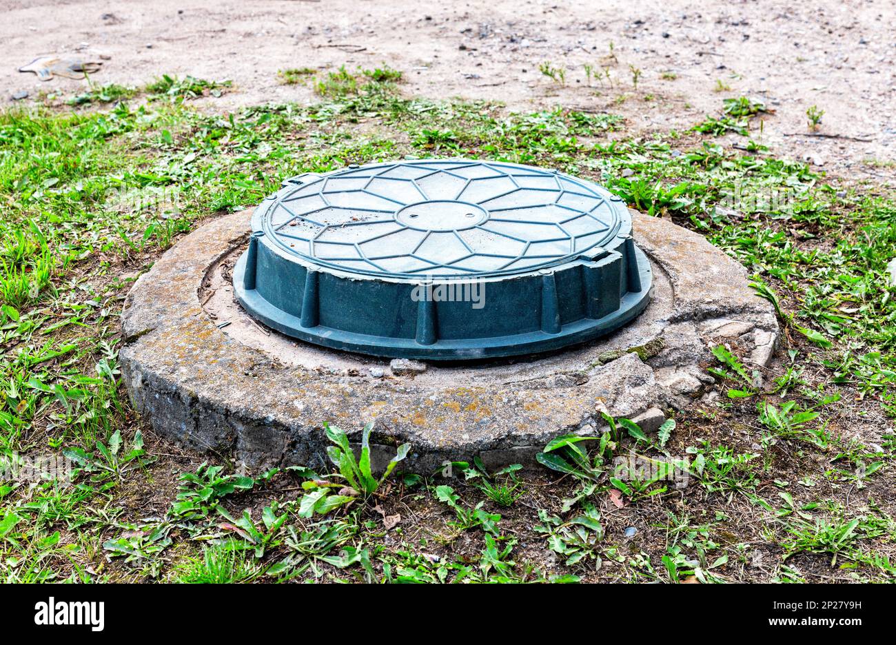 Covered sewer manhole of rural septic tank with green plastic cover ...
