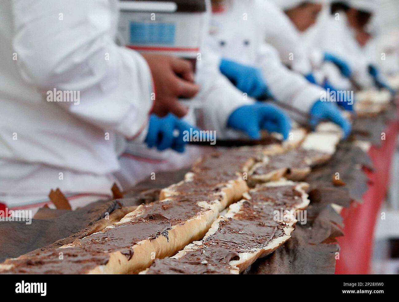 Bakers smear a record long baguette with Nutella at the Expo 2015 world ...