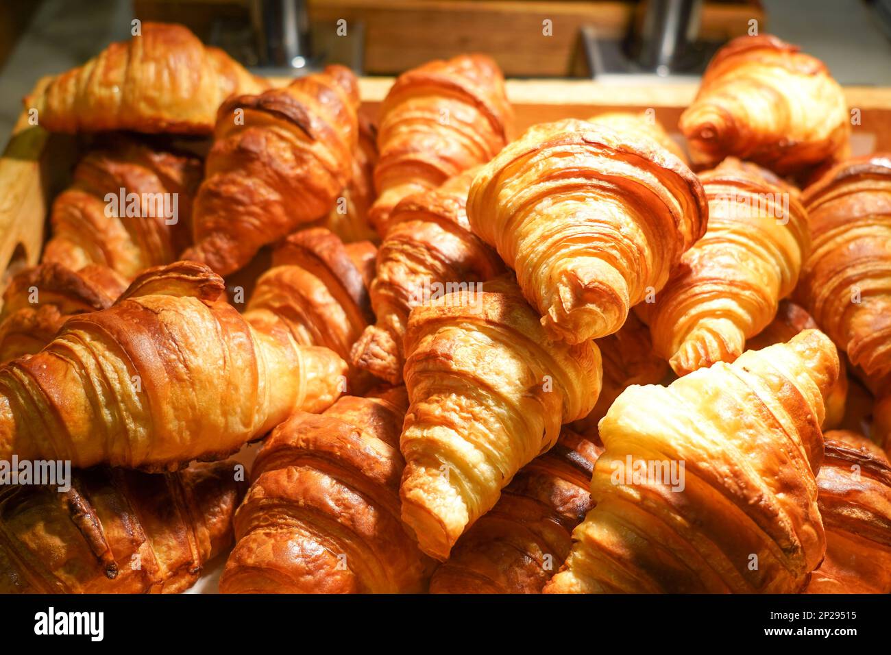 Croissants and cinnamon rolls in a display shelf for breakfast Stock ...