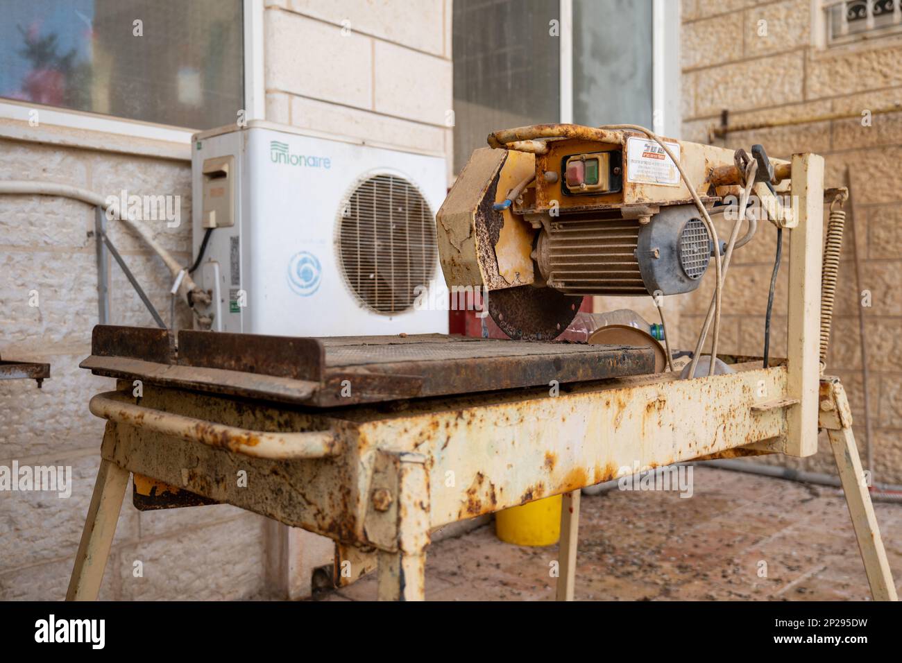 Old Rusty Job Site Electric Miter Table on Stand Against A House Wall ...