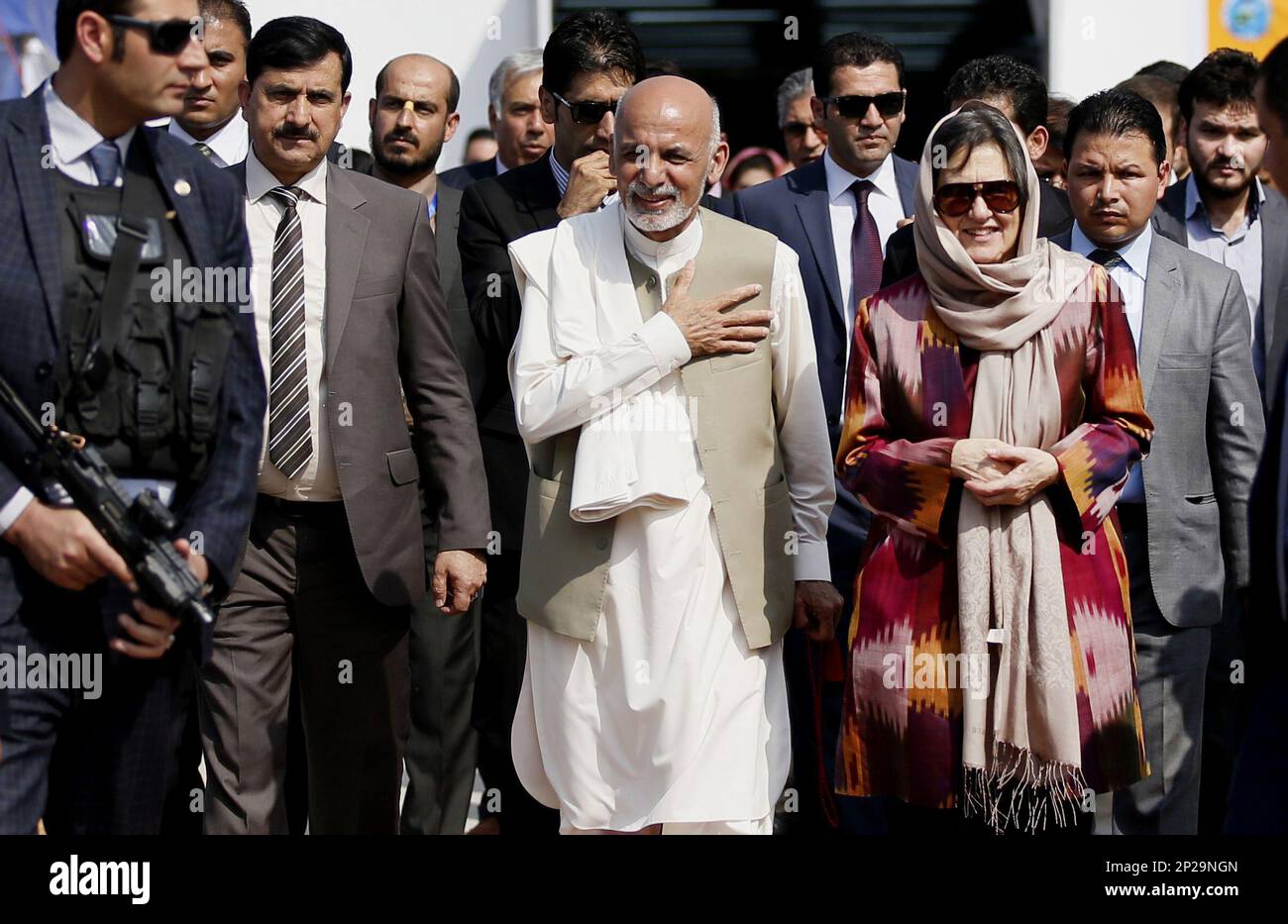 Afghan President Ashraf Ghani, center, walks with his wife Rula Ghani ...