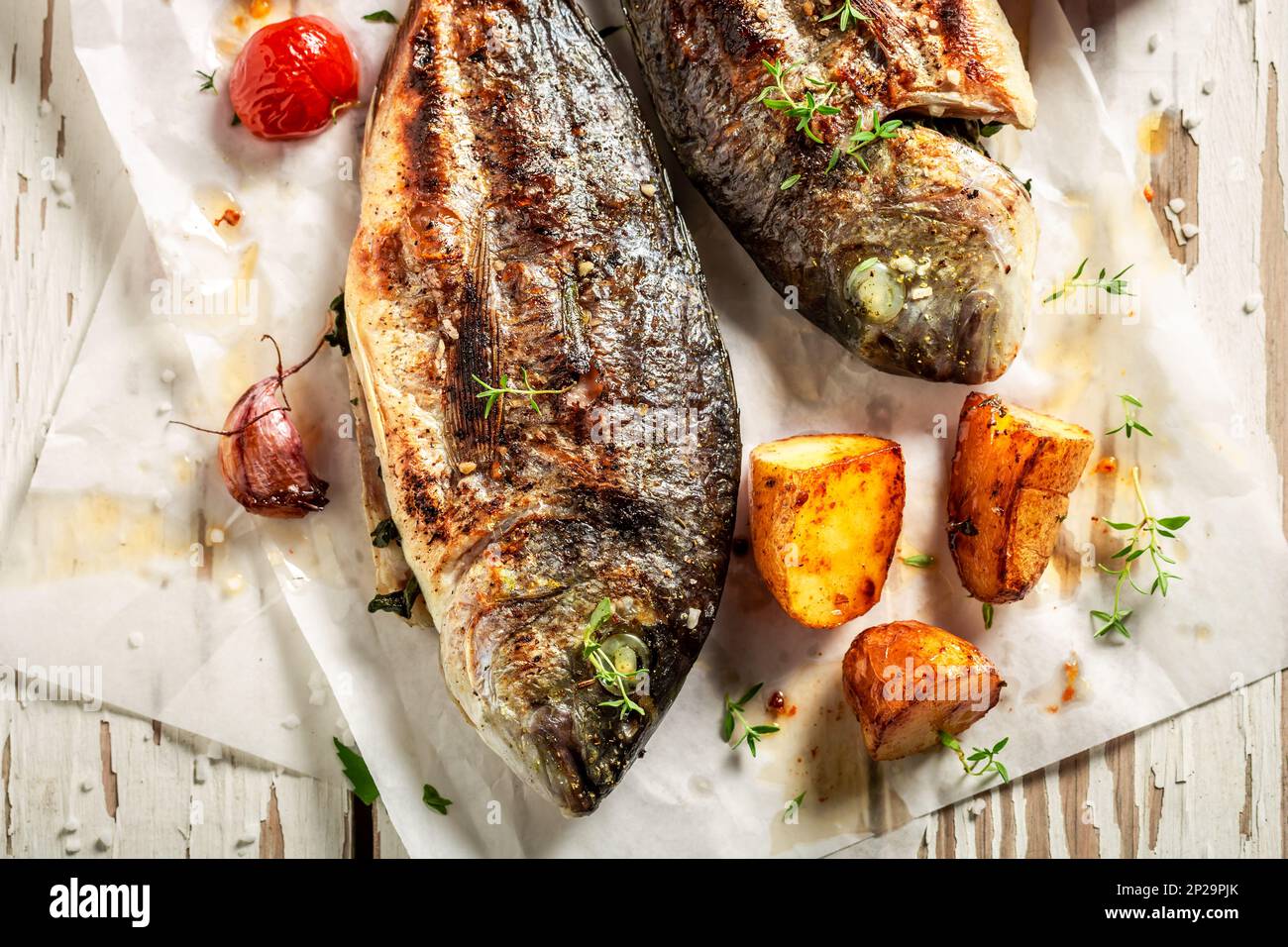 Tasty roasted sea bream with potatoes, cherry tomatoes and thyme Stock ...