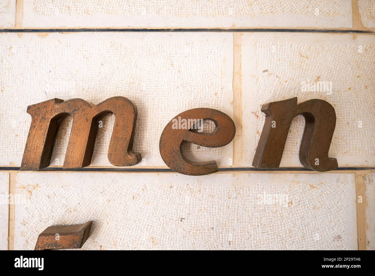 Large Golden "men" Symbol on a White Brick Wall Stock Photo - Alamy