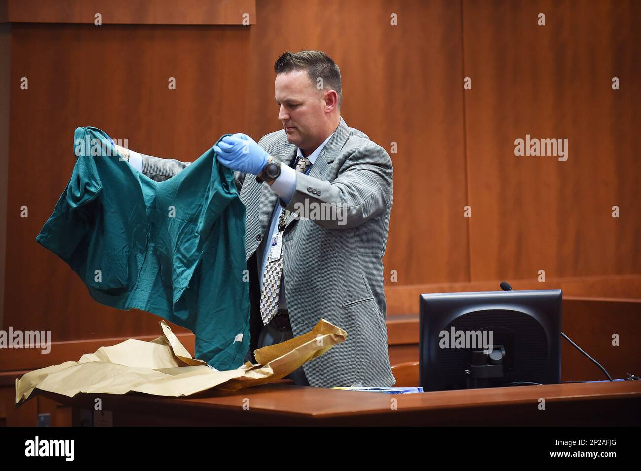 Alexandria police officer Patrick Lennon holds up a piece of clothing ...