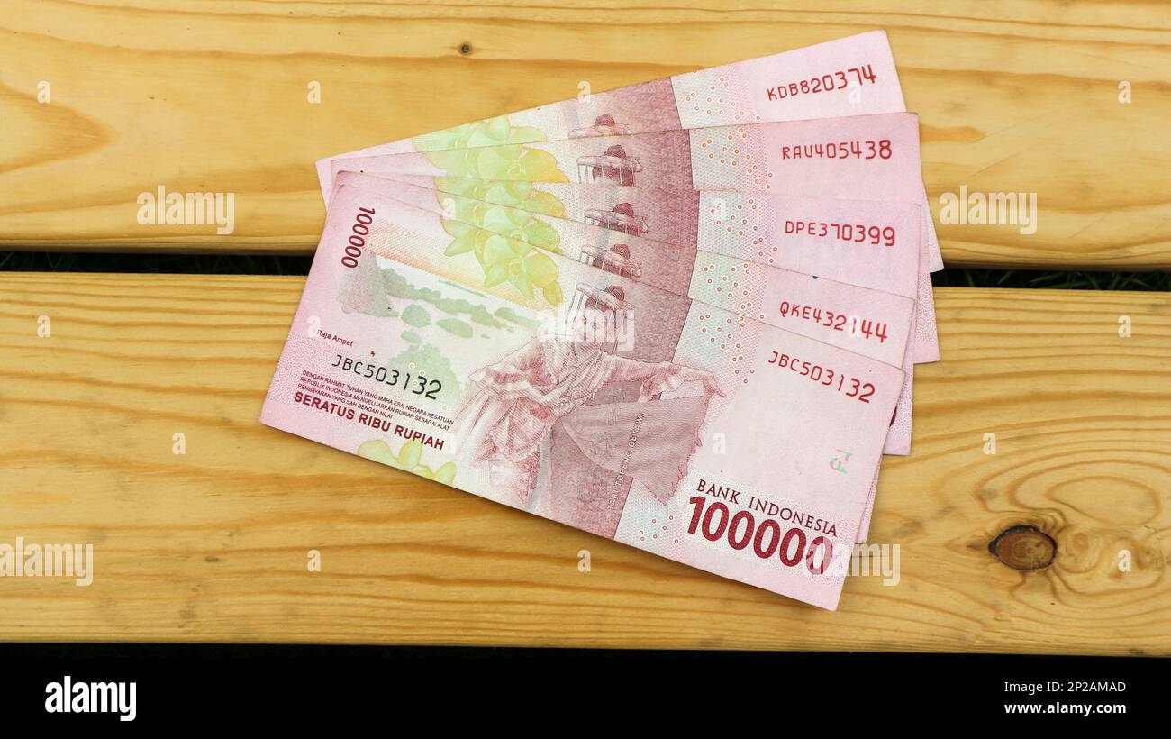 Indonesian thousand rupiah notes are isolated on a wooden plank ...