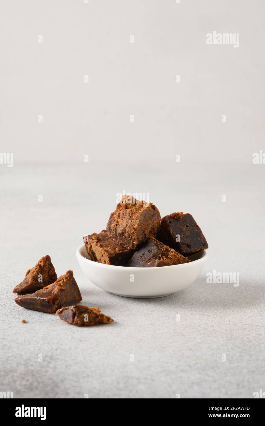 Kithul jaggery and treacle natural sweetener in bowl on gray background ...