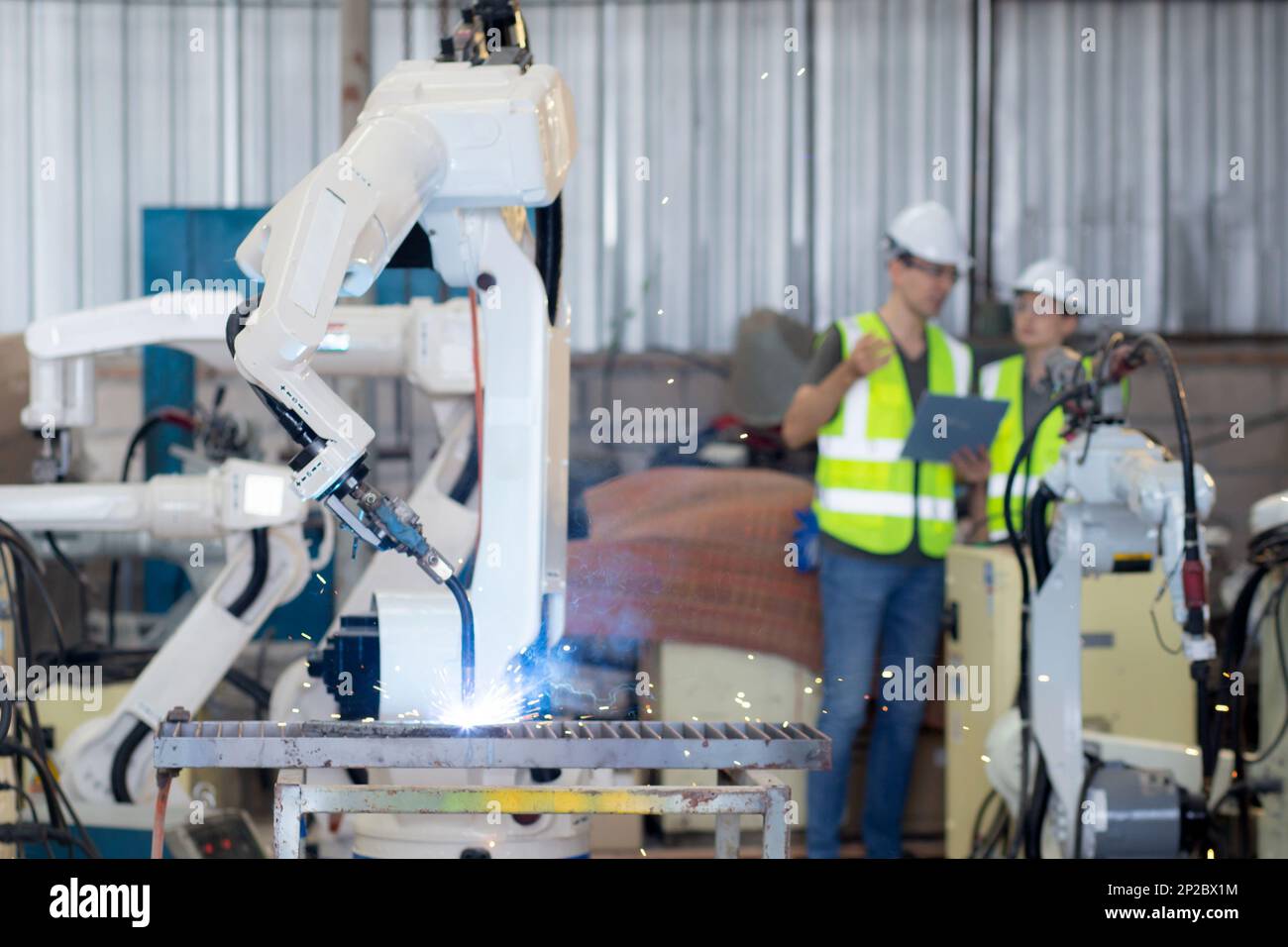 Engineer man and woman talking and explaining about robot arms ...