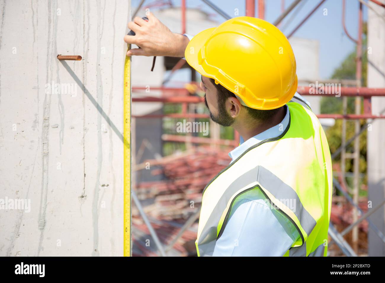 Engineer young man using tape measure for check and examining length of ...