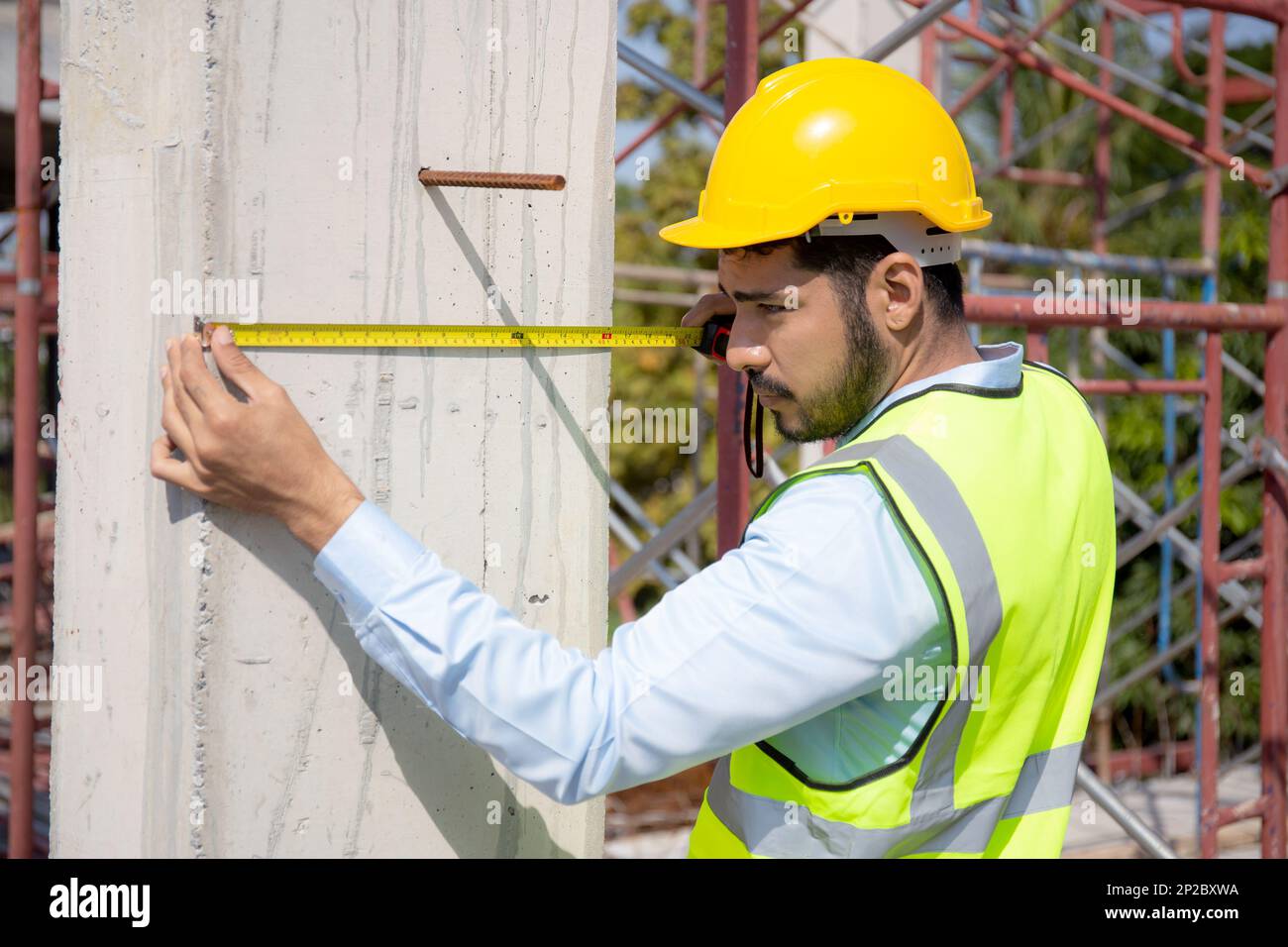 Engineer young man using tape measure for check and examining length of ...
