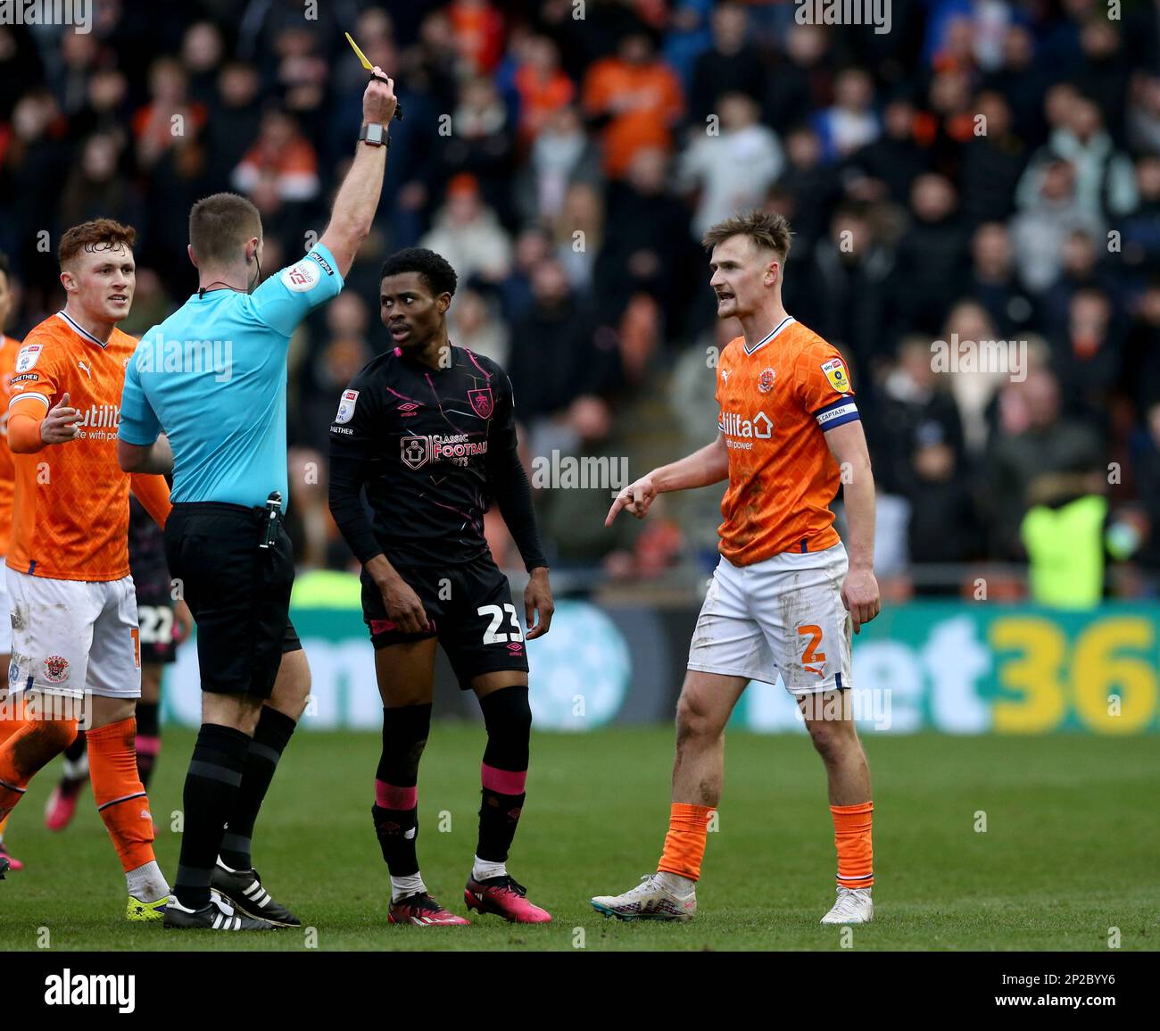 Burnley's Nathan Tella (second right) is booked for a foul by referee ...