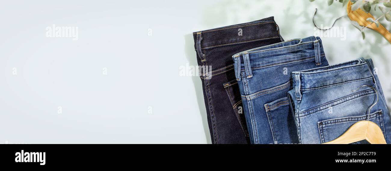 Sustainable shopping banner with different kind of jeans with wooden ...