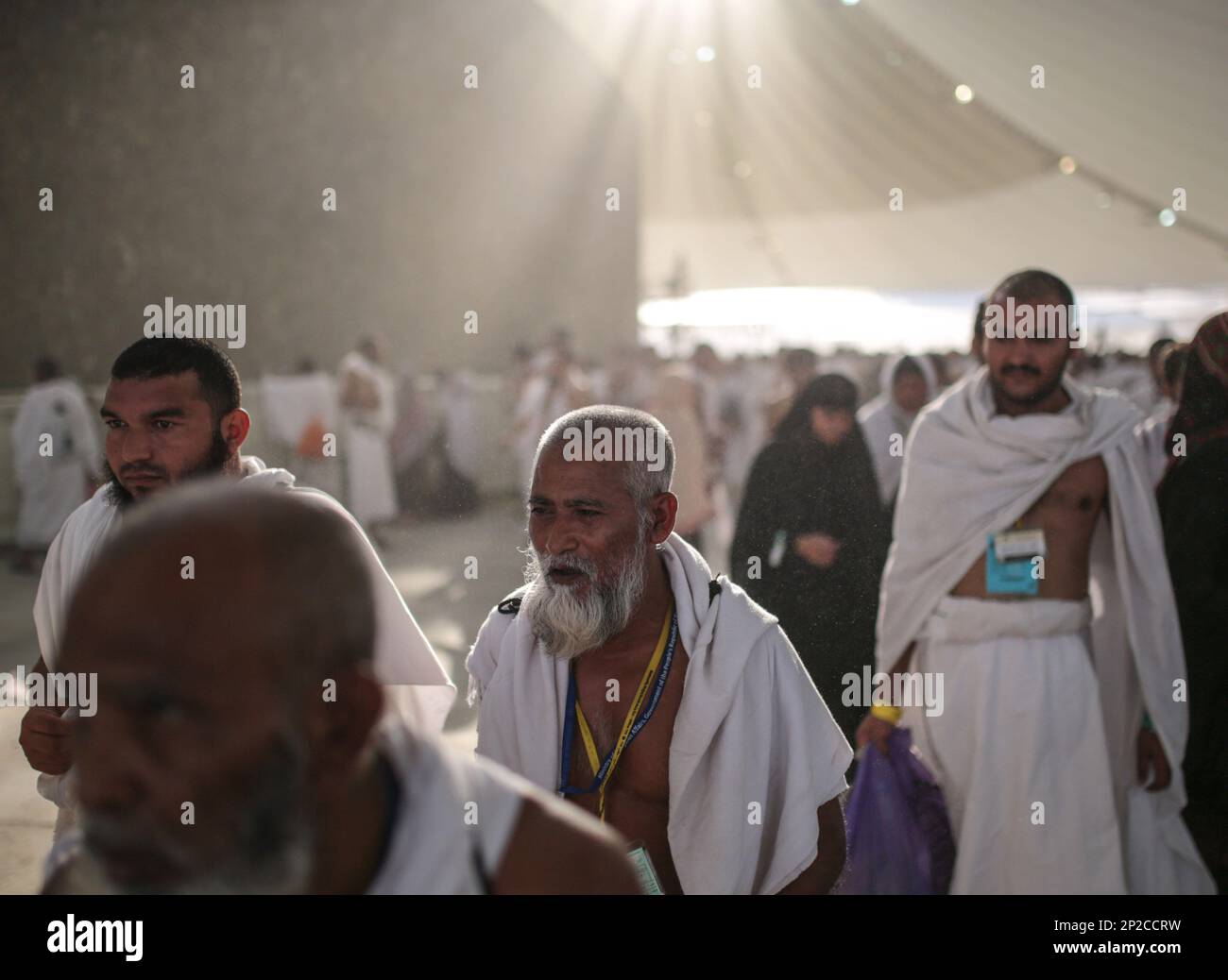 Muslim pilgrims walk after casting stones at a pillar symbolizing the ...