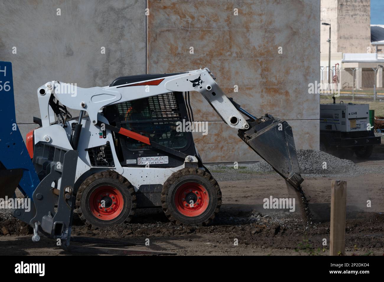 A civilian contractor operates a Bobcat 530 skid-steer loader at the ...