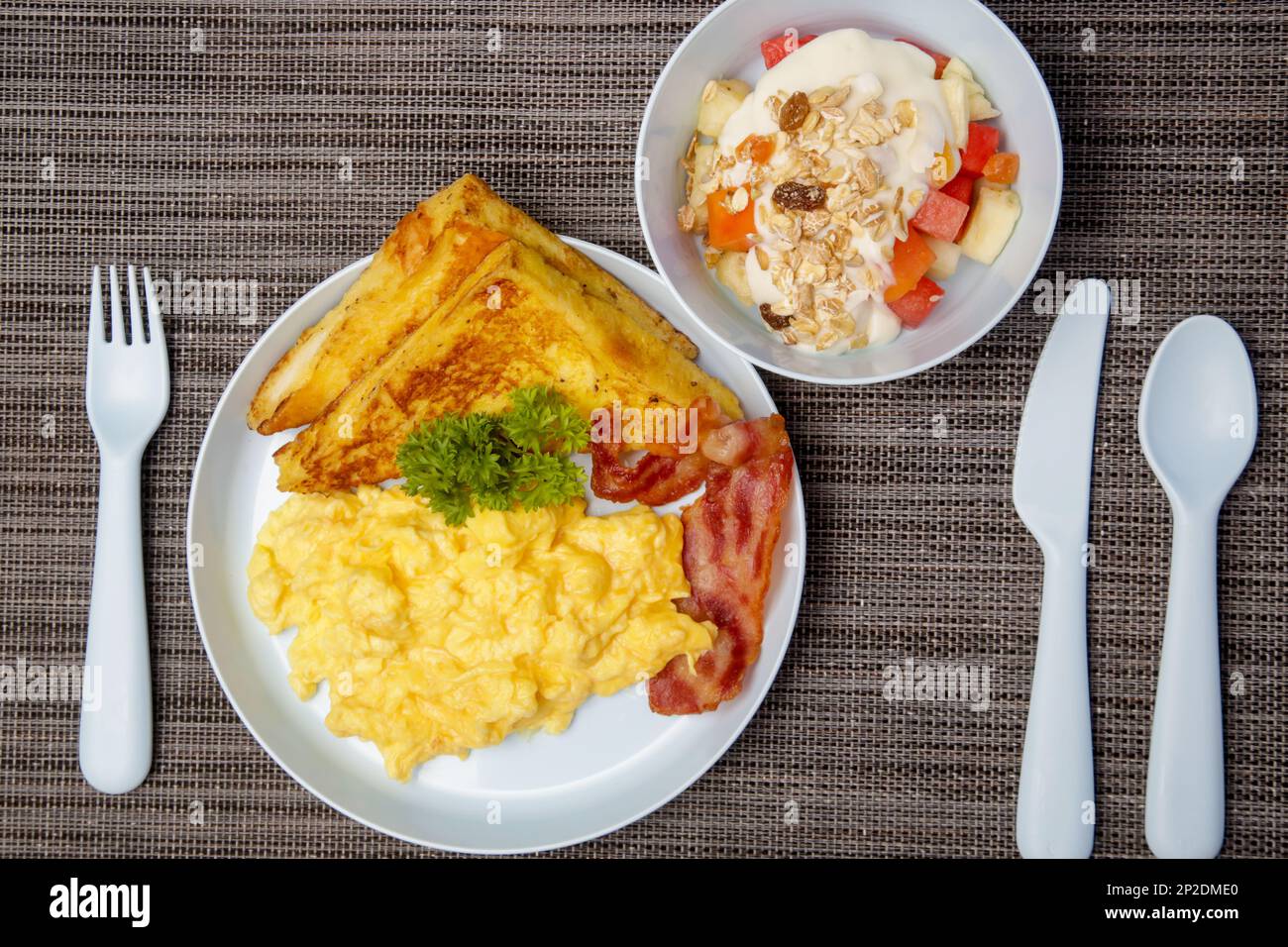 Kids menu, scrambled eggs, bacon, toast and muesli with yoghurt served ...