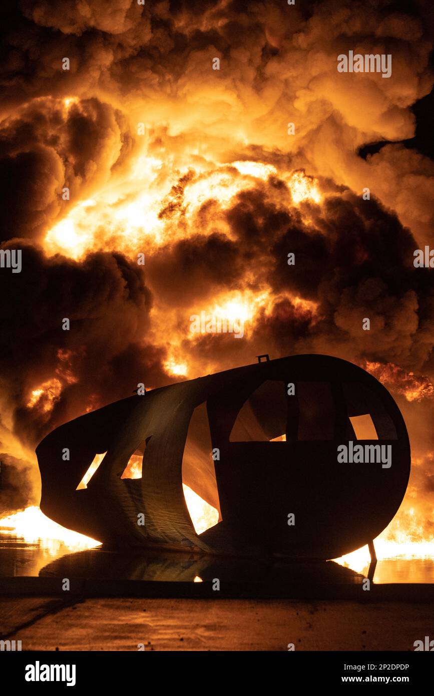 A simulated aircraft fuel fire rages around an aircraft husk during an ...