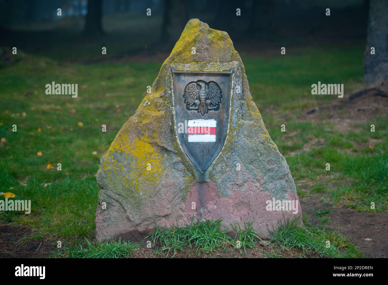 A large obelisk is placed next to the tourist trail with a trail sign ...
