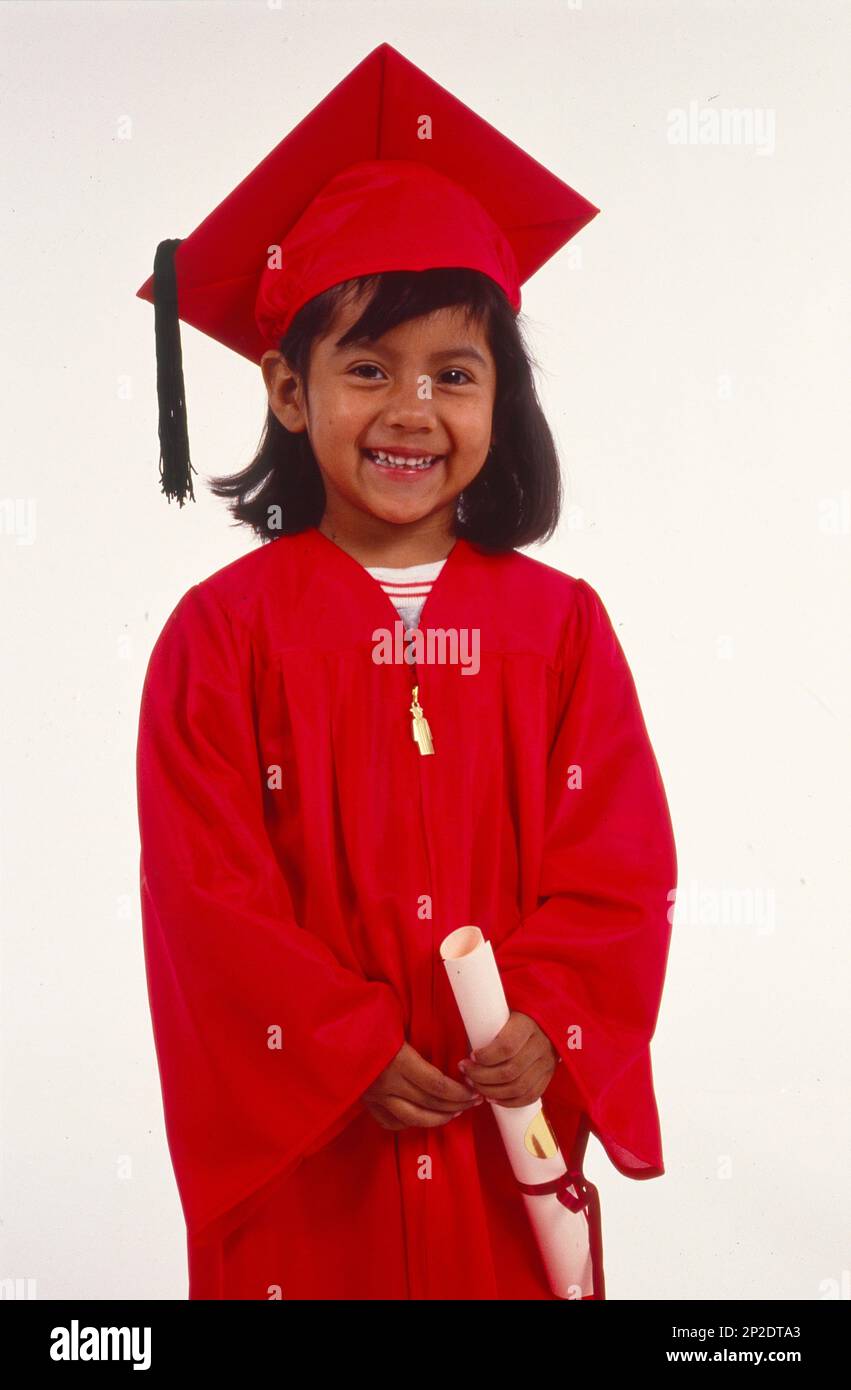 Portrait of a little Asian girl in a red graduation gown and Holding a ...
