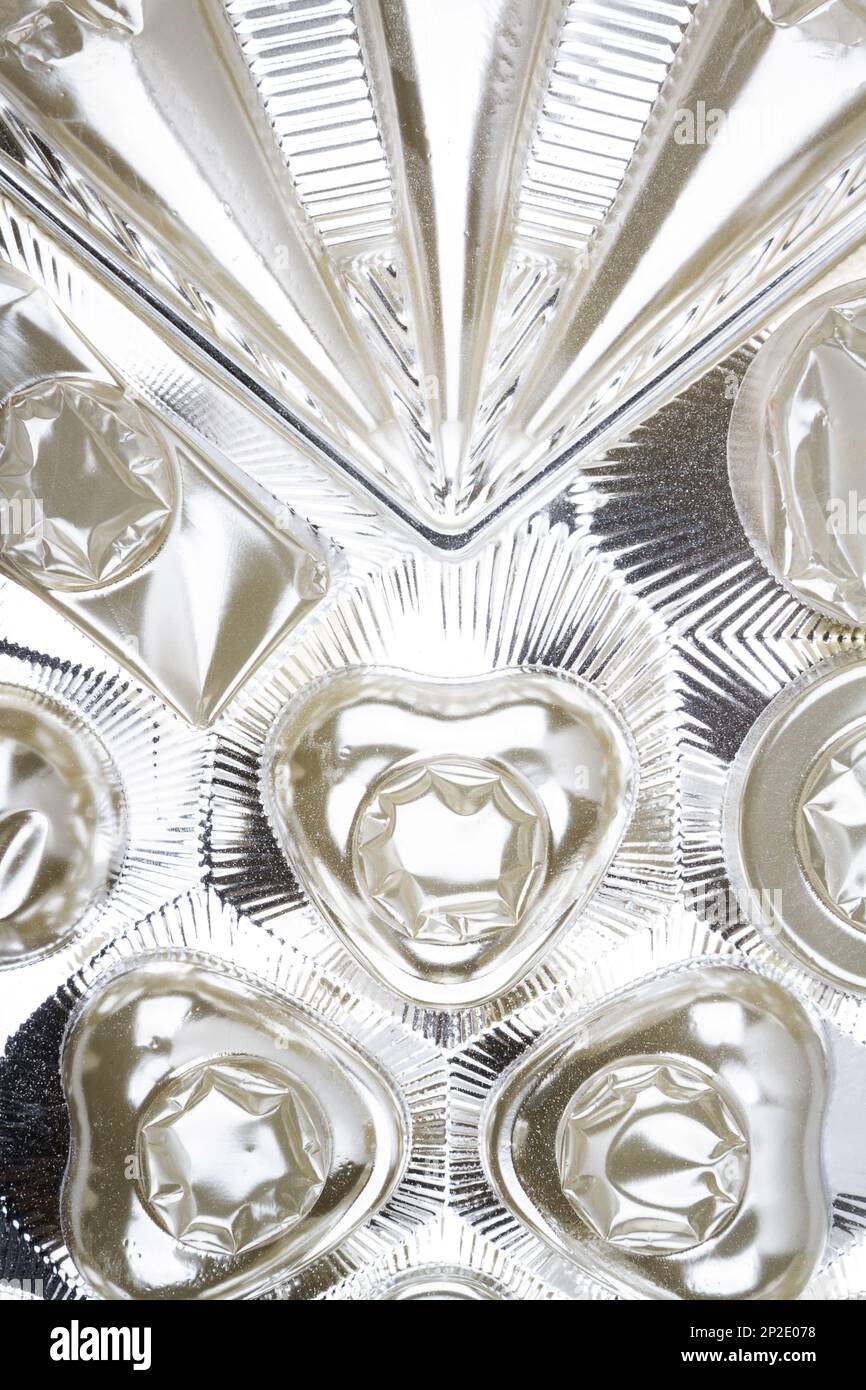 Close up shot of empty box of chocolates. Shiny gold plastic texture of ...