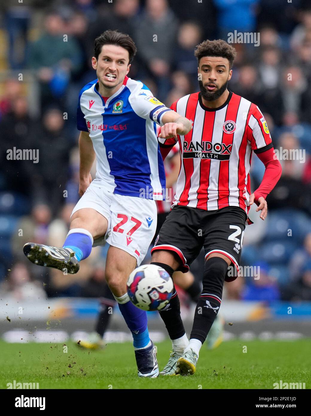 Lewis Travis #27 of Blackburn Rovers clears the ball under pressure ...