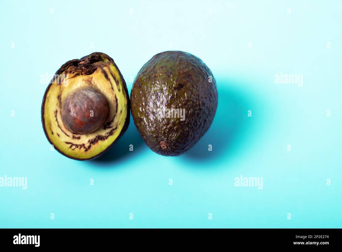 Rotten avocado, overriped, bad avocado. Half sliced fruit, freegan food ...
