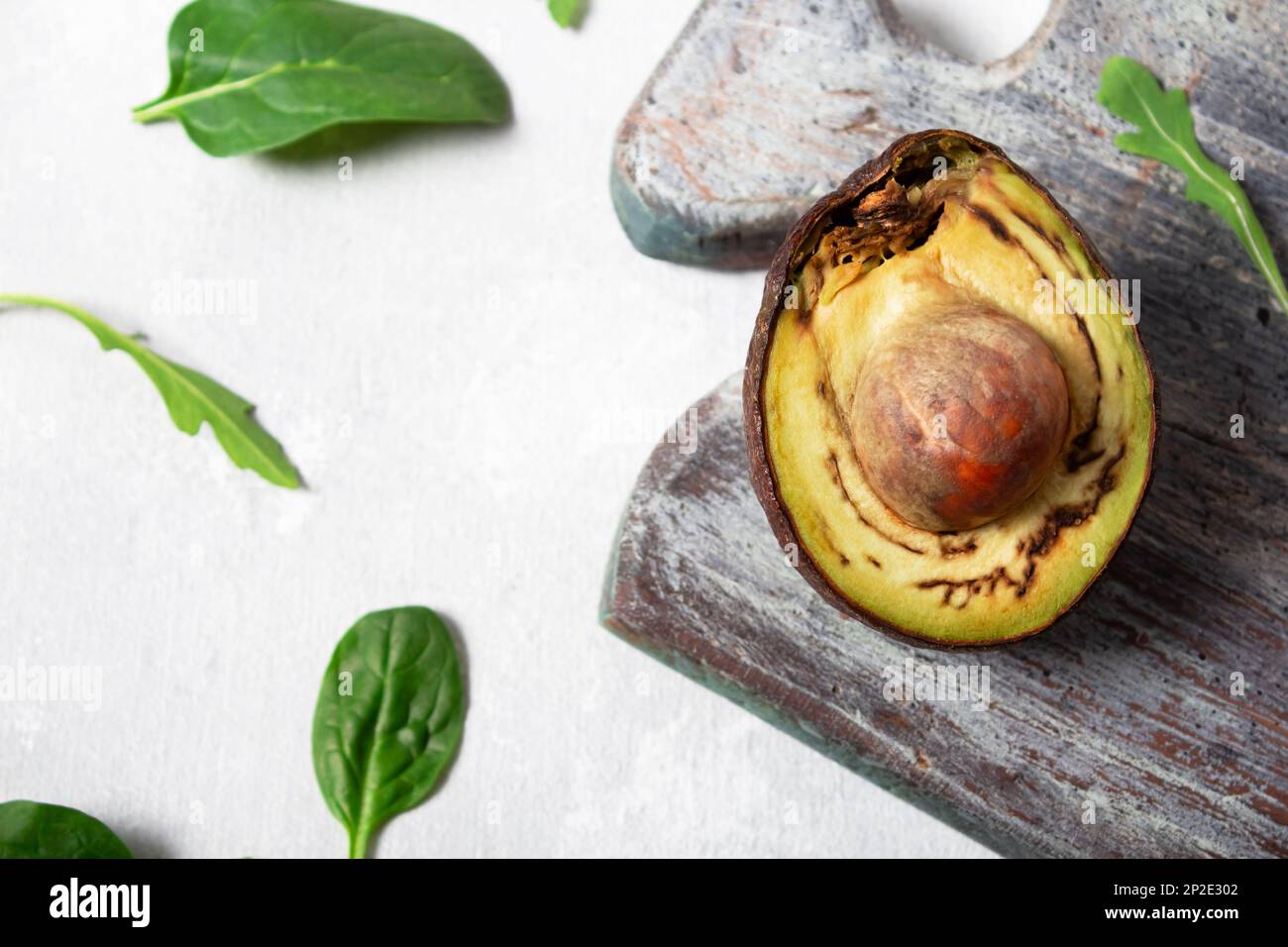 Rotten avocado, overriped, bad avocado. Half sliced fruit on cutting ...