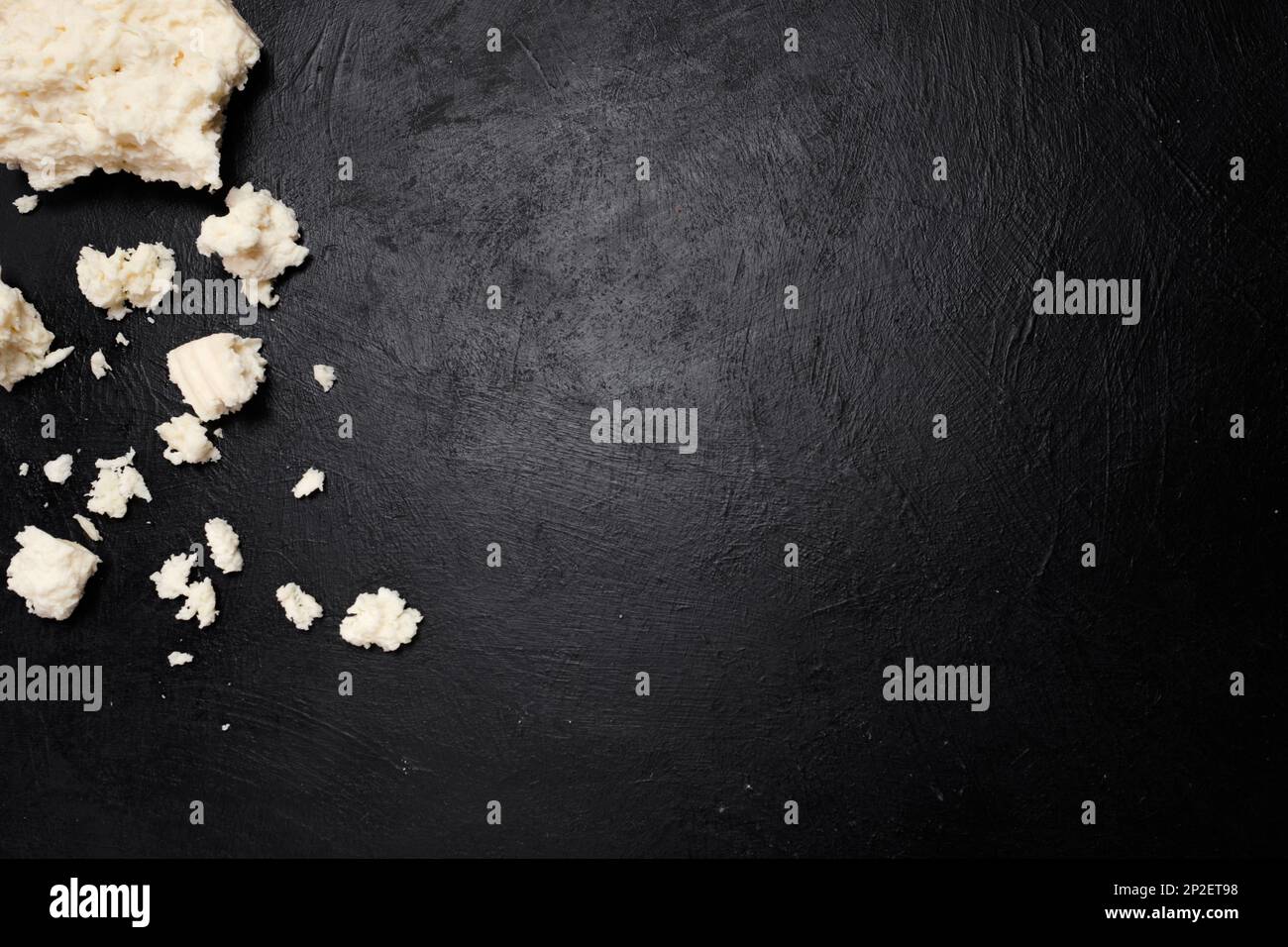 crumbling feta cheese on dark background Stock Photo - Alamy