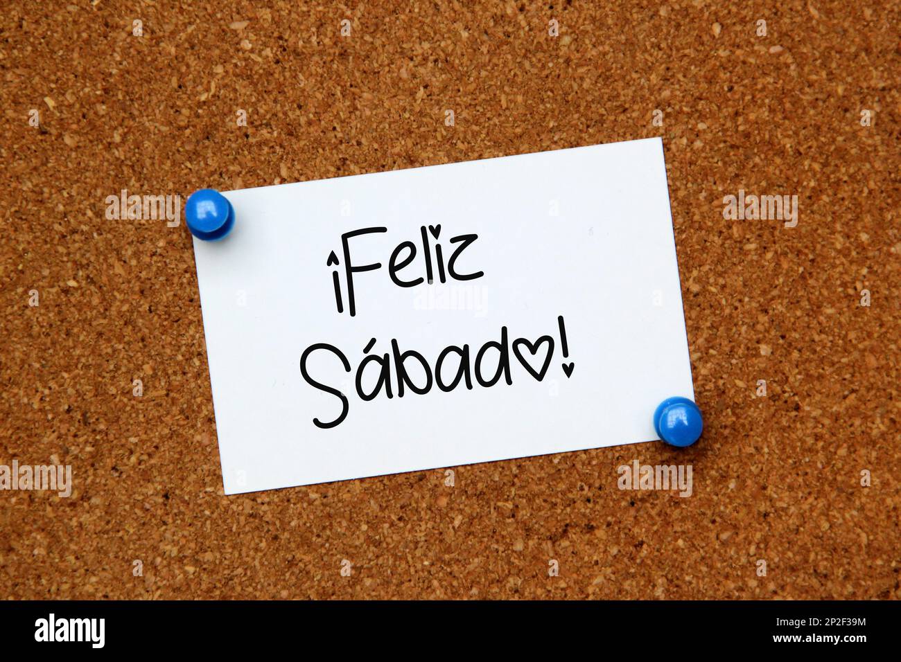 White and colored notes on cork board with message in spanish language ...