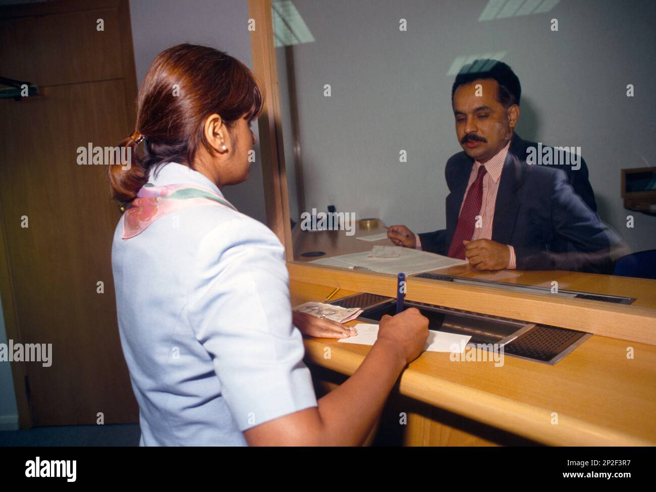 Bank Cashdesk London England Muslim Woman signing Form Stock Photo - Alamy