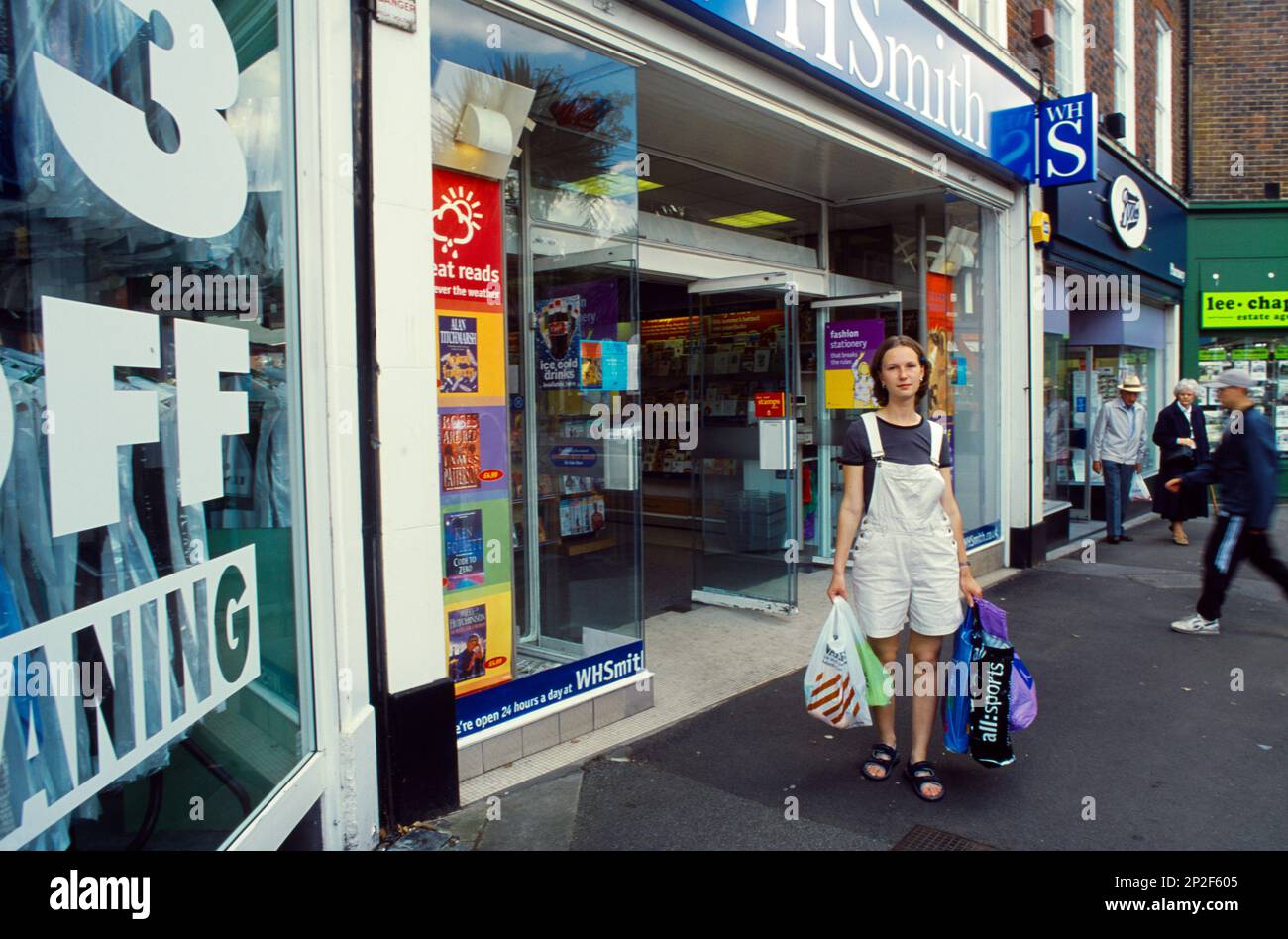 Woman Shopping Carrying Shopping Bags In Street Cheam Village Surrey ...