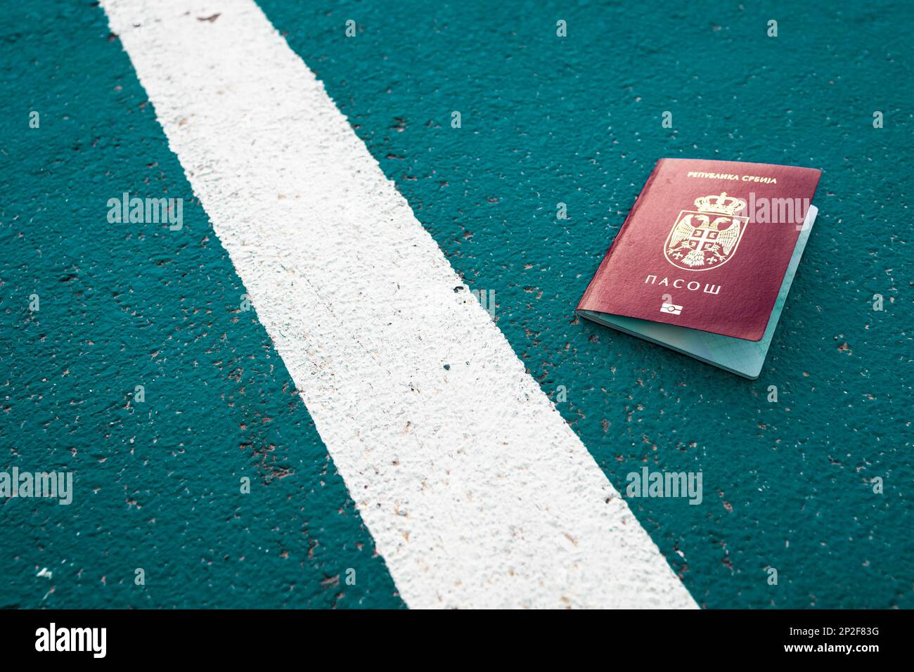 National Serbian passport next to a white line on the ground. Symbolic ...