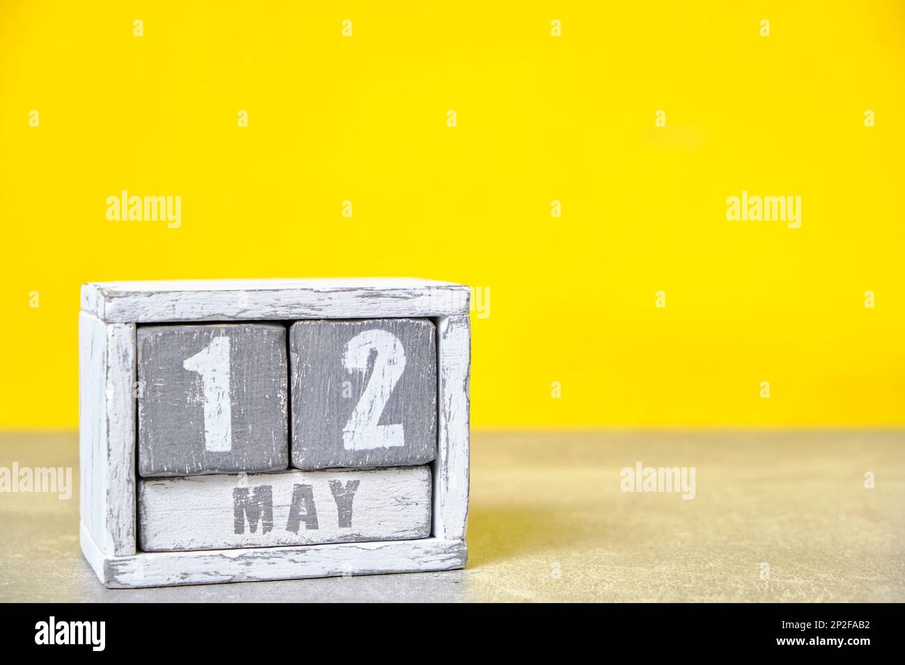 May 12 calendar made wooden cubes yellow background.With an empty space ...