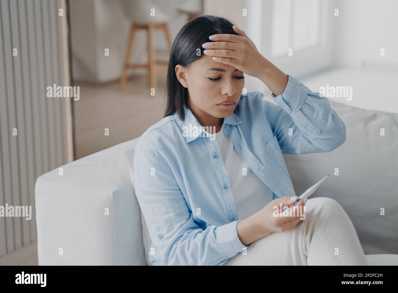 Unhealthy female suffer from fever check body temperature, holding ...