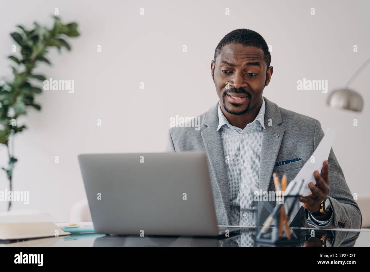 Working at his desk looking at notice hi-res stock photography and ...