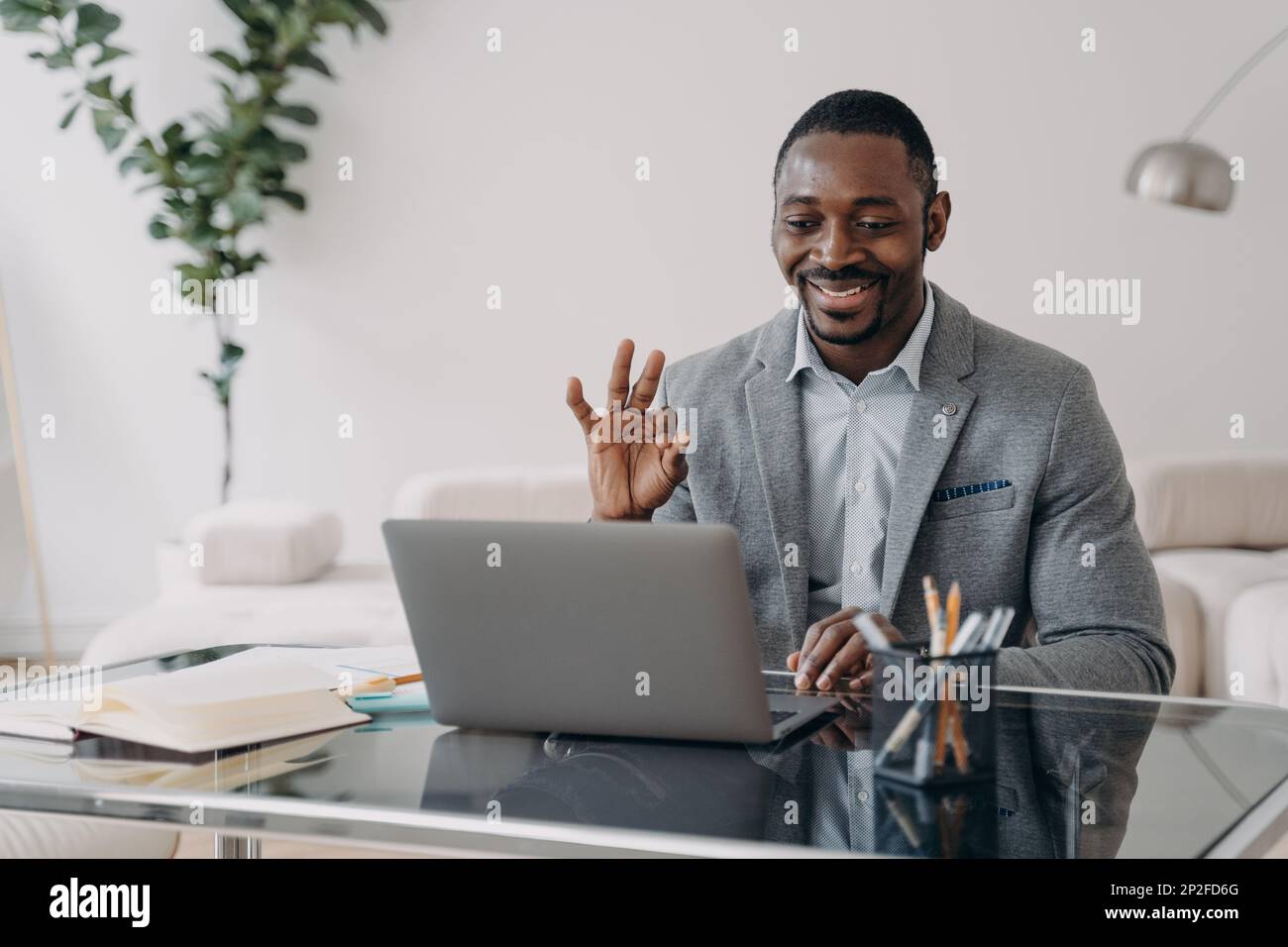 Smiling african american man talk by video call using laptop app agree ...