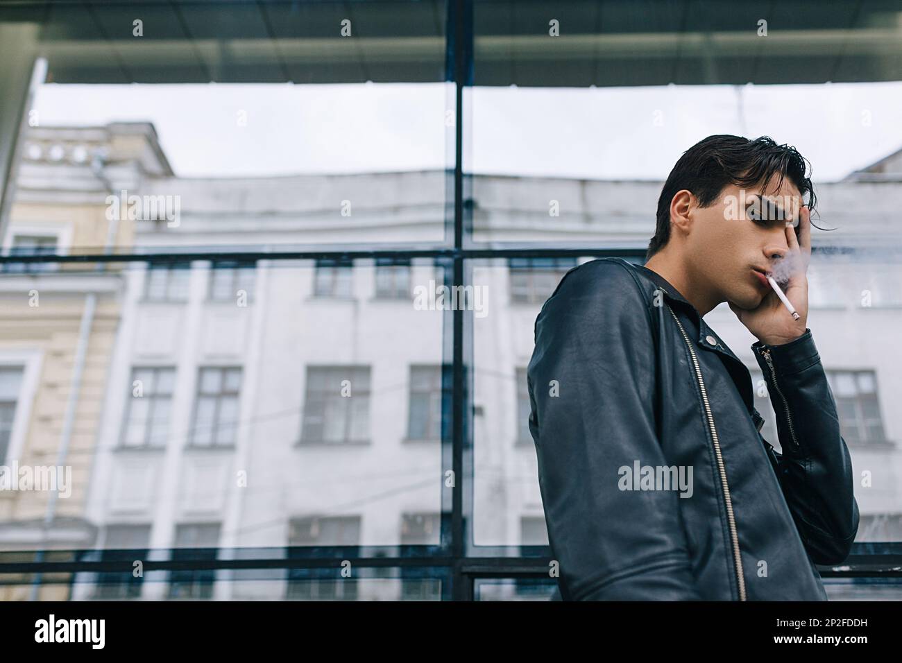 emotional cool rock style man smoking. bad habit Stock Photo - Alamy