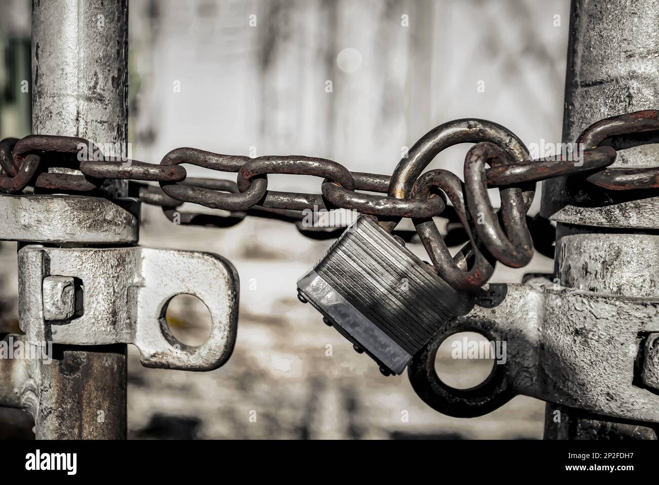 A heavy duty chain connected with a lock around two steel posts Stock ...