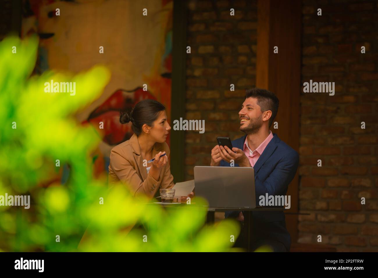 Two beautiful business colleagues are sitting in a cafe bar after work ...