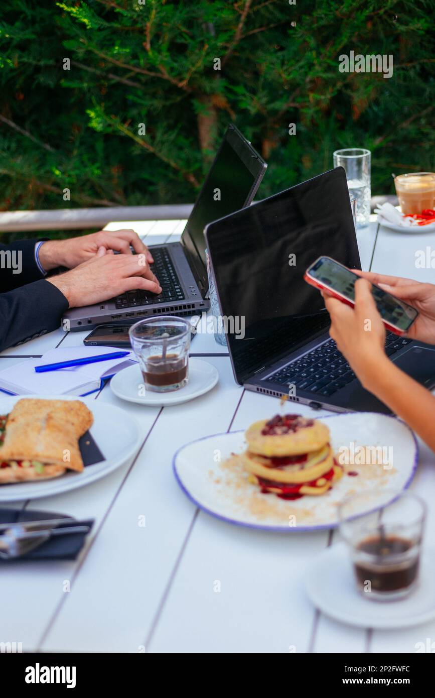 A male business person is working on his lap top while his female ...