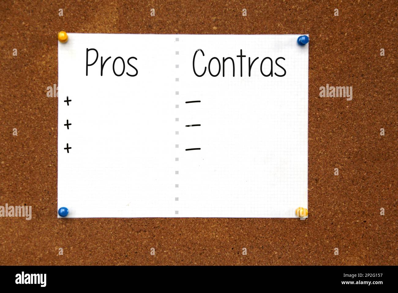 White note on cork board with message in Spanish language "Pros y cons ...