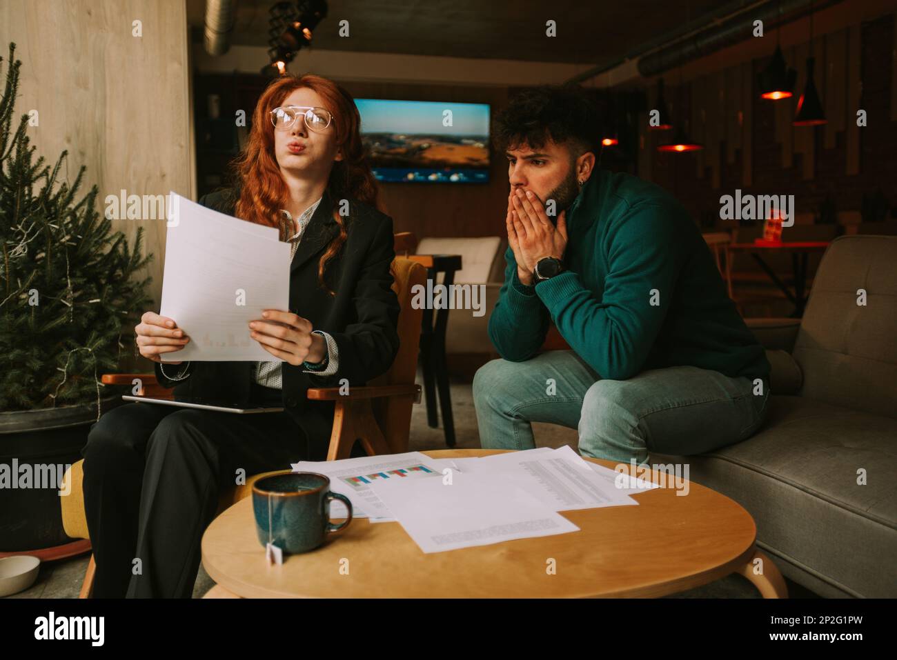 Beautiful young stylish business partners look worried and confused ...