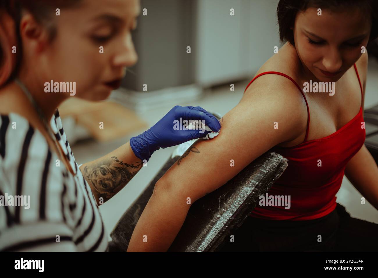 Close up of the tattoo artist cleaning the tattoo of her client Stock ...