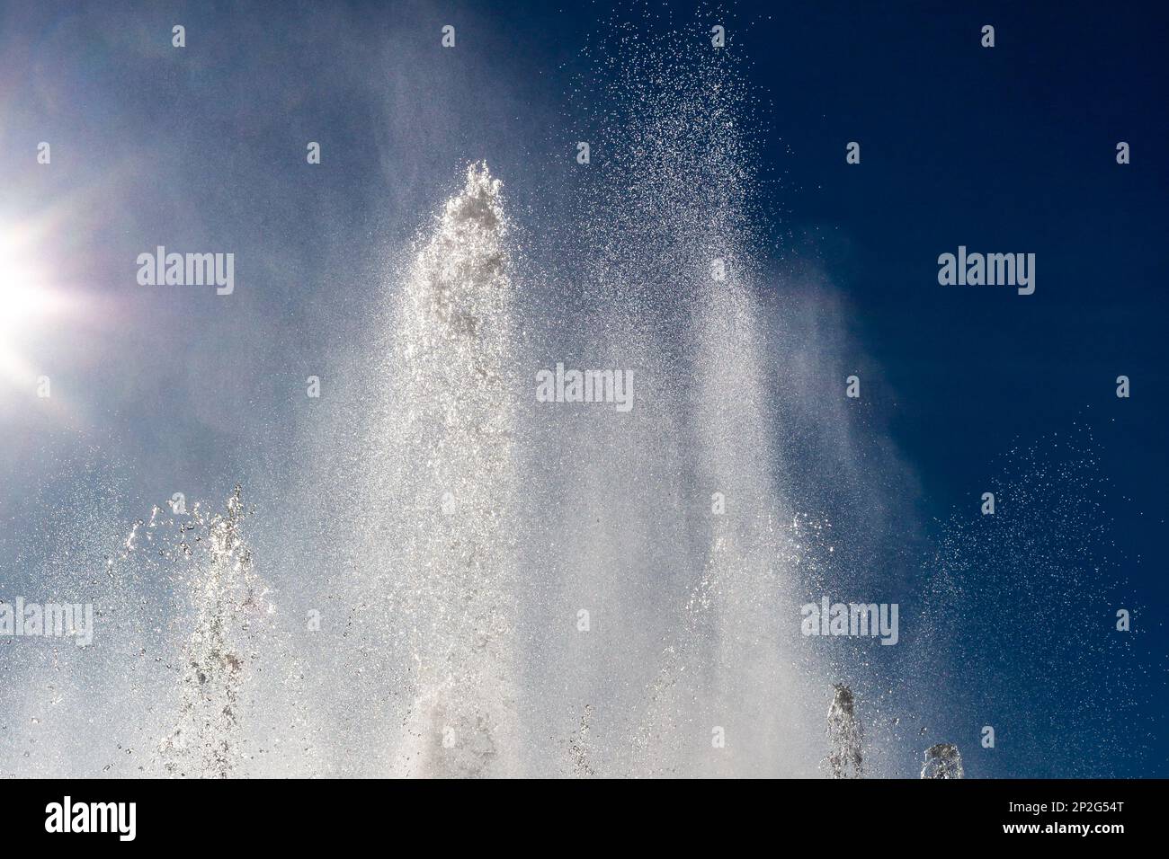 Water spraying from a fountain with a blue sky behind Stock Photo - Alamy