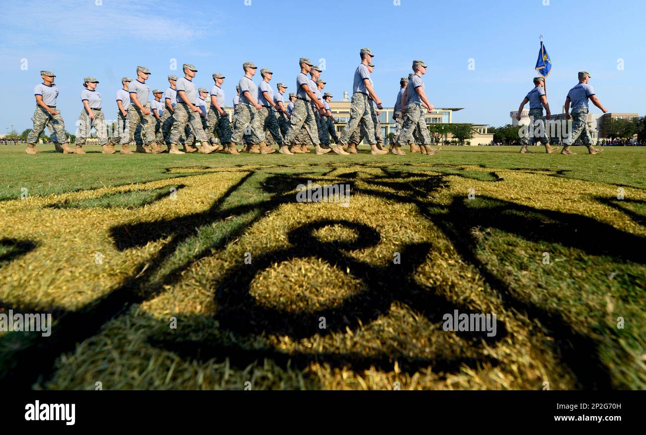 Members of the Texas A&M Corps of Cadets march past the Corps logo that ...