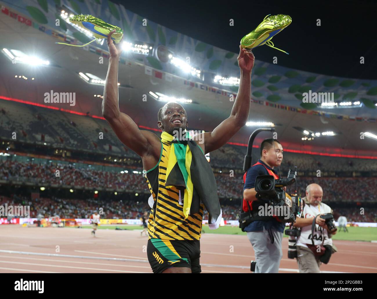 Jamaican's Usain Bolt holds his shoes after winning the 200-meter final ...